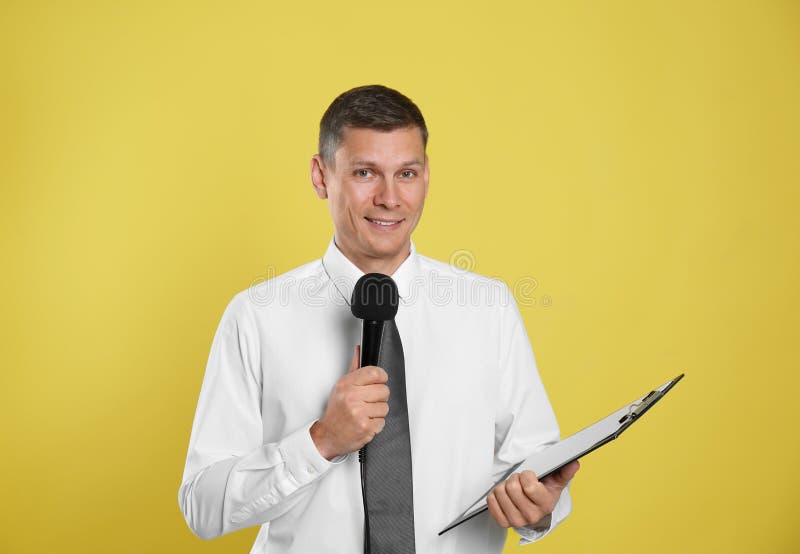 Male Journalist With Microphone And Clipboard On Background Stock Image ...