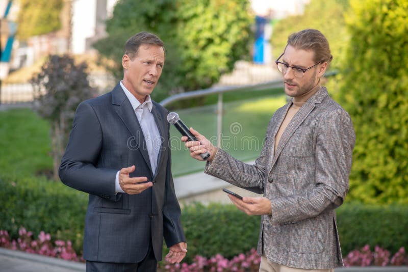 Male Journalist Taking Taking Inteview with Mature Man, Recording it ...