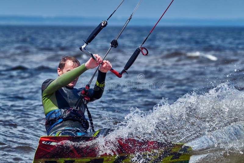 A Male Kiter Slides on the Surface of the Water. Stock Image - Image of ...