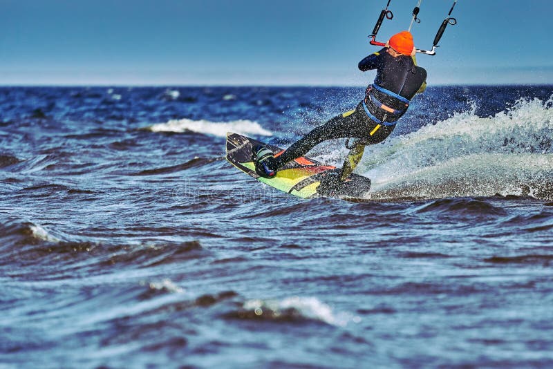 A Male Kiter Slides on the Surface of the Water. Splashes of Water Fly ...