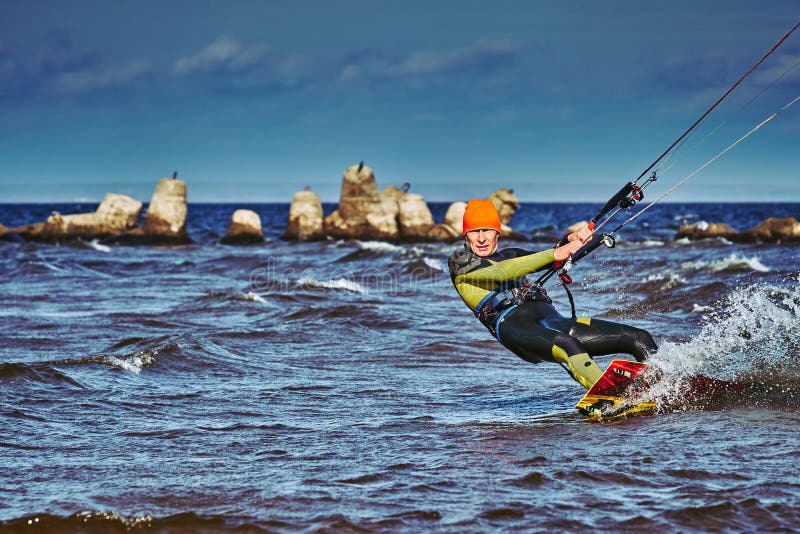 A Male Kiter Slides on the Surface of the Water. Splashes of Water Fly ...