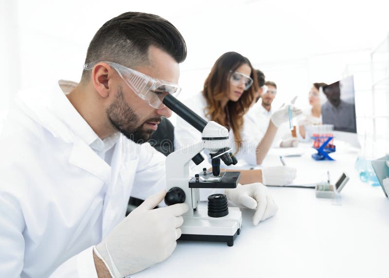 Male Lab Technician Looks at the Sample Under a Microscope Stock Photo ...