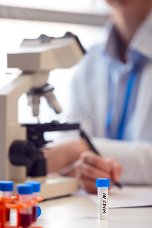 Male Lab Worker Conducting Research Using Microscope with Test Labelled ...