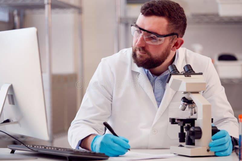 Male Lab Worker Wearing White Coat Recording Test Results on Computer ...