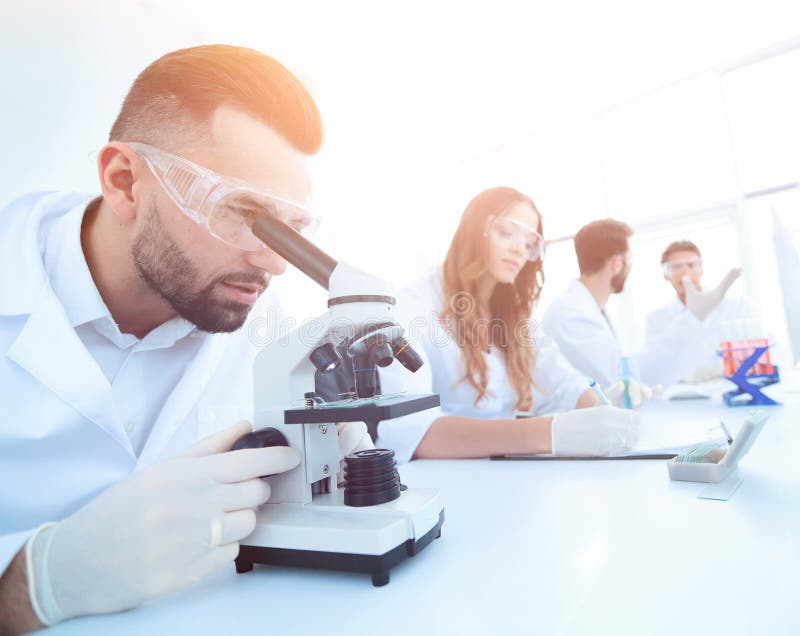 Male Laboratory Technician Looking at Samples in the Microscope Stock ...