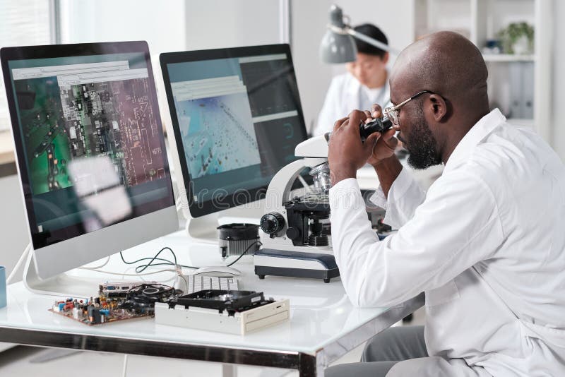 Male Laboratory Worker in Whitecoat Studying Details of Microchip Stock ...