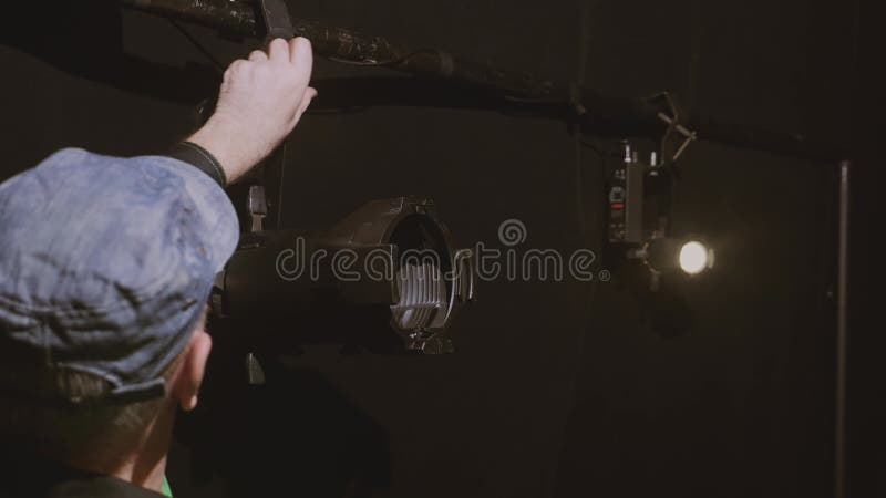A Male Lighting Engineer Hangs a Profile Spotlight on a Tripod Device ...