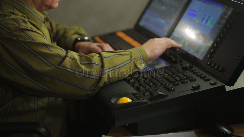 A Male Lighting Operator at the Remote Control Programs the Stage Light ...