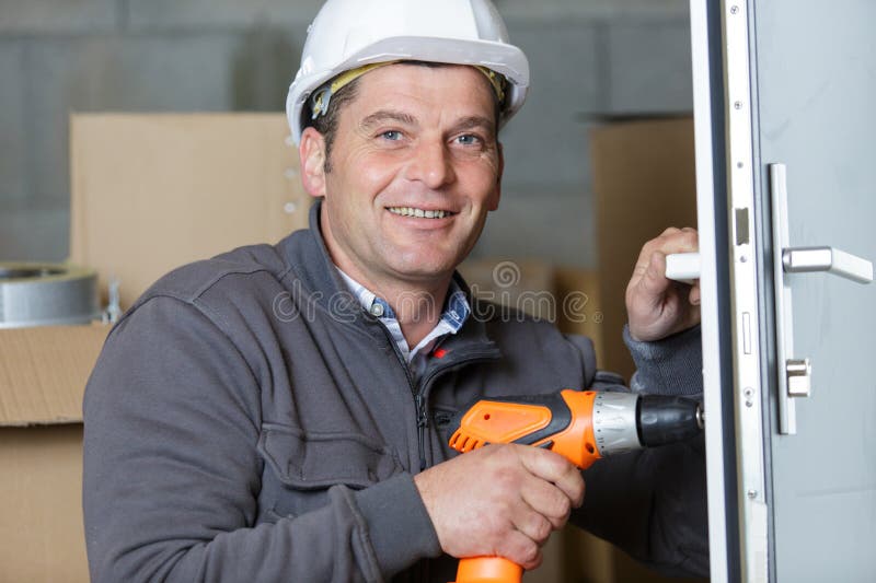 Male Locksmith Using Cordless Screwdriver on Door Lock Stock Photo ...