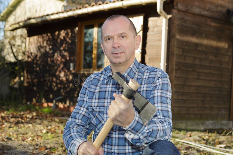 Male Lumberjack Walks Along a Forest Road with a Chainsaw and an Ax ...