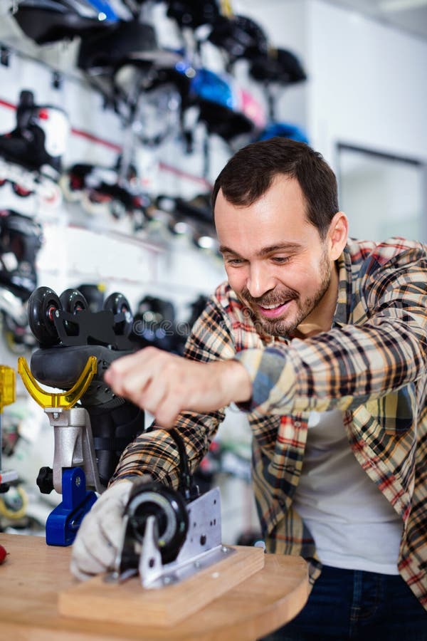 Male Master Fixing Roller-skates in Sports Store Stock Image - Image of ...