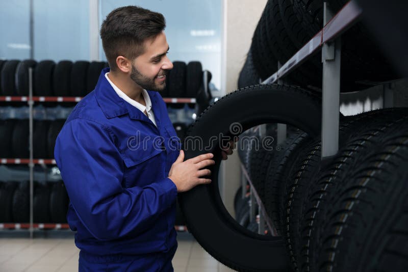 Male Mechanic with Car Tire in Store Stock Image - Image of mechanic ...