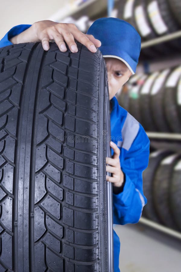 Male Mechanic Checks a Tire Seriously Stock Image - Image of store ...