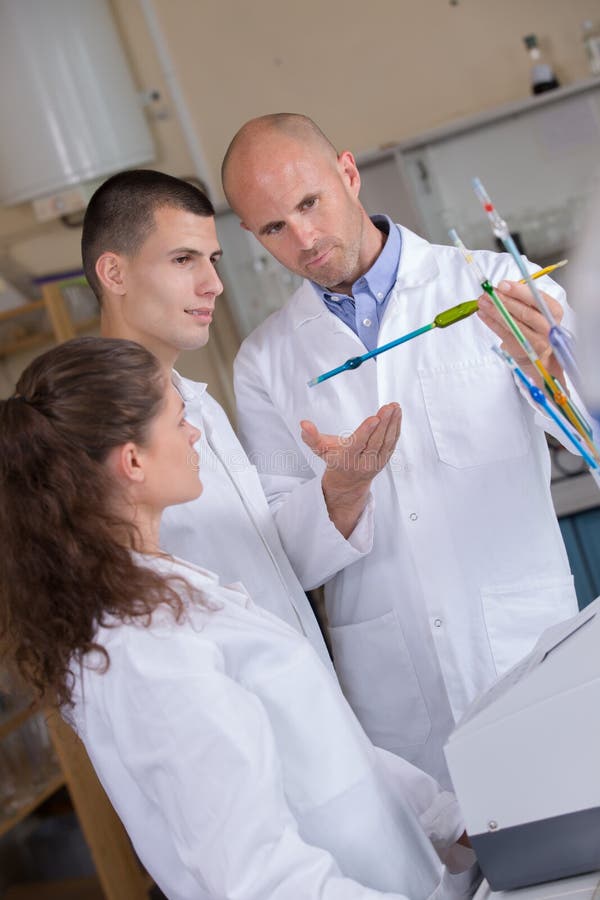 Male Medical Teacher and Students Performing Test Stock Photo - Image ...