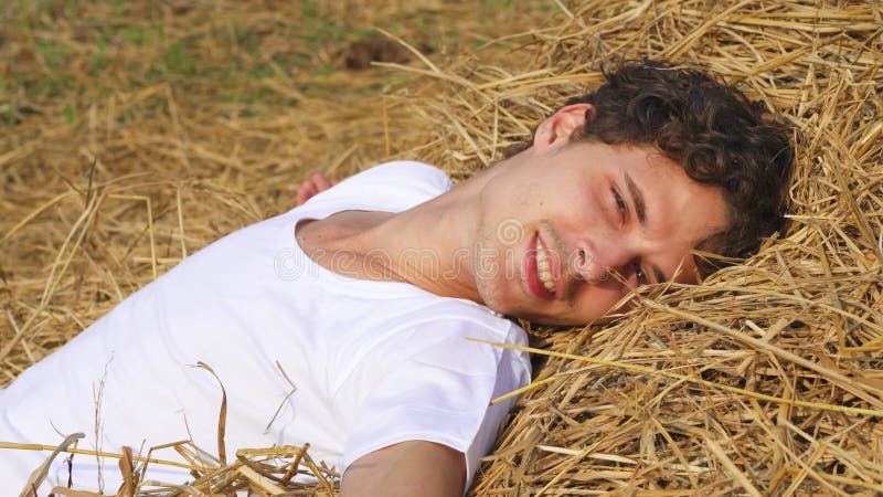 Male Model Looks into the Camera Lying on a Haystack Stock Footage ...