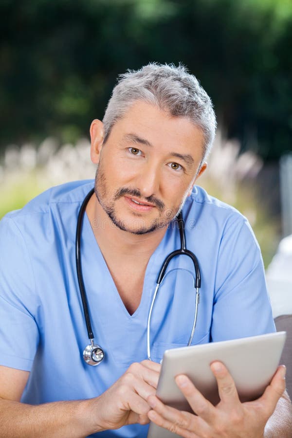 Male Nurse Using Digital Tablet at Nursing Home Stock Photo - Image of ...