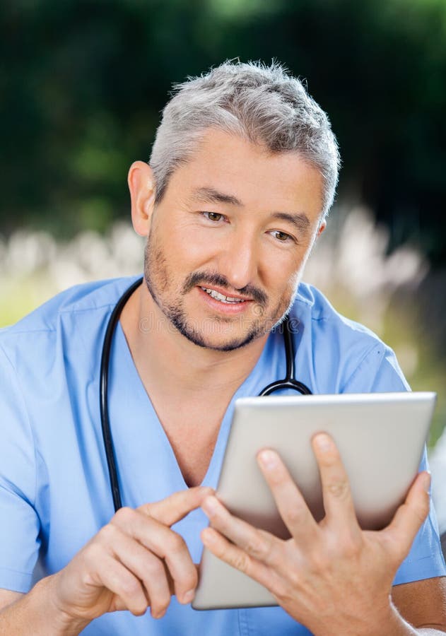 A Nurse Sitting at a Computer Stock Photo - Image of scrubs, confidence ...