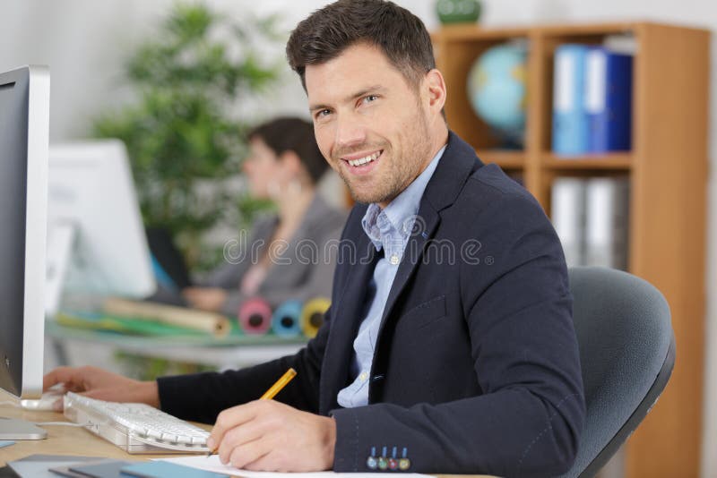 Male Office Worker Sitting at Desk Stock Photo - Image of sitting ...