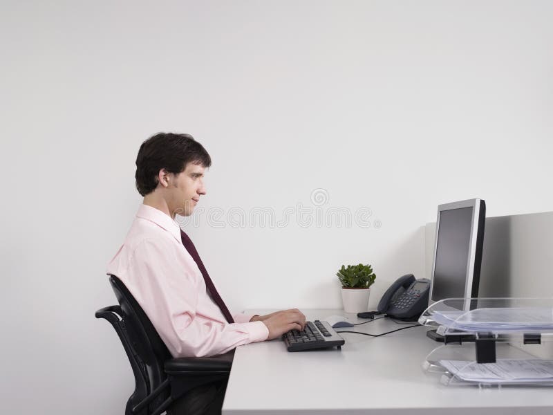 Male Office Worker Using Computer at Desk Stock Image - Image of ...