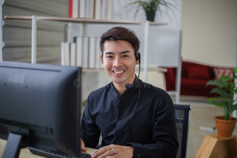 Male Officer Working and Smiling in Customer Service Office Stock Photo ...