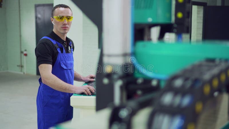 A Male CNC Machine Operator is Typing on the Control Panel. Stock ...
