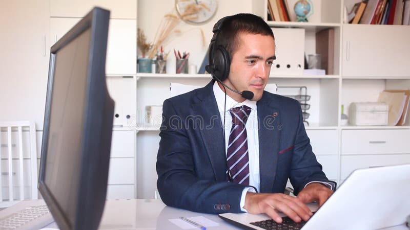 Male Operator Talking with Customer Using Headset at Company Office ...