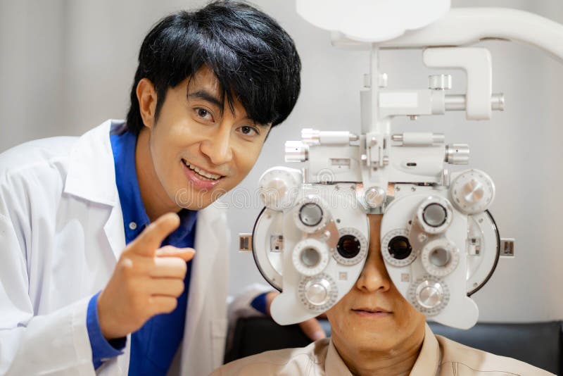 Male Optometrist with Phoropter while Examining Patient Stock Photo ...