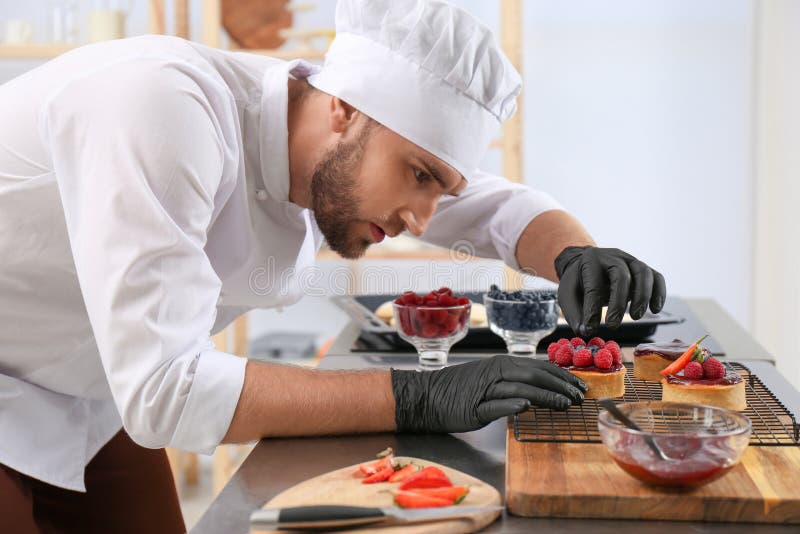 Male Pastry Chef Preparing Cake at Table in Kitchen Stock Photo - Image ...