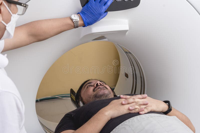 A Male Patient Goes Inside a CT Scan Gantry Operated by a Technician ...