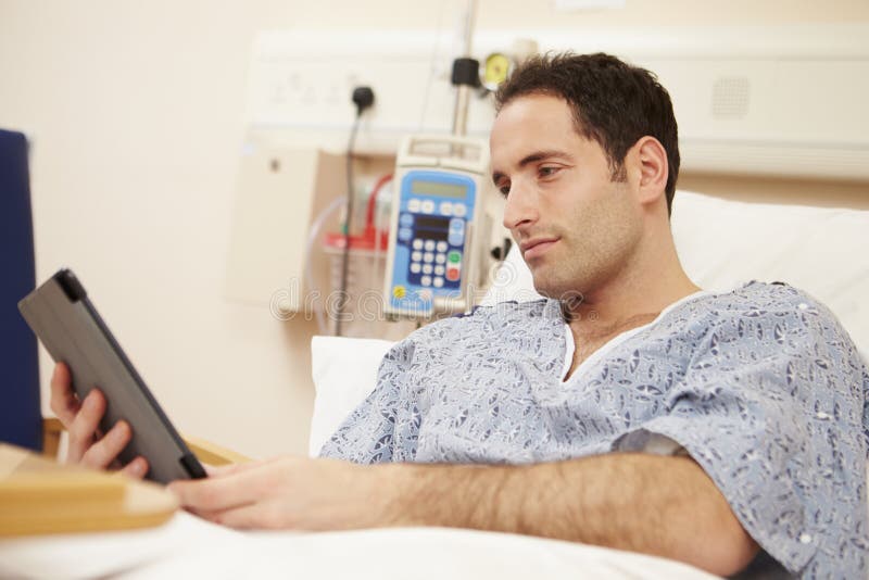Male Patient Using Digital Tablet in Hospital Bed Stock Photo - Image ...
