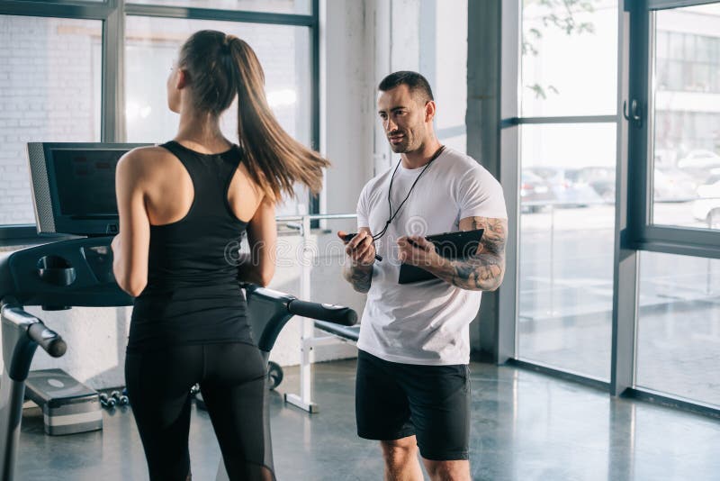 Male Personal Trainer Using Timer while Sportswoman Stock Photo - Image ...