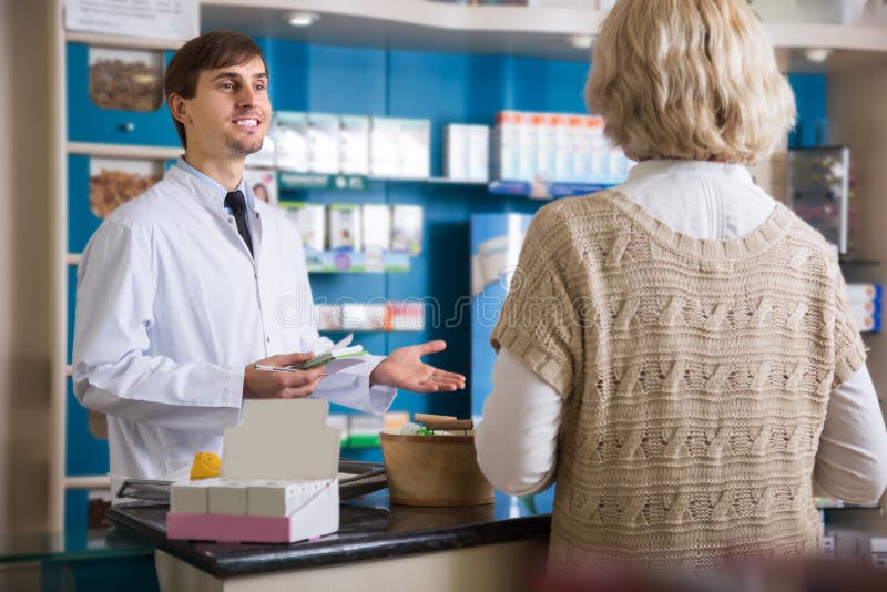 Male Pharmacist Talking To Customer at Pharmacy Stock Photo - Image of ...