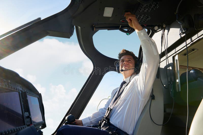 Male Pilot in Cockpit of Helicopter Doing Pre Flight Check before Take ...