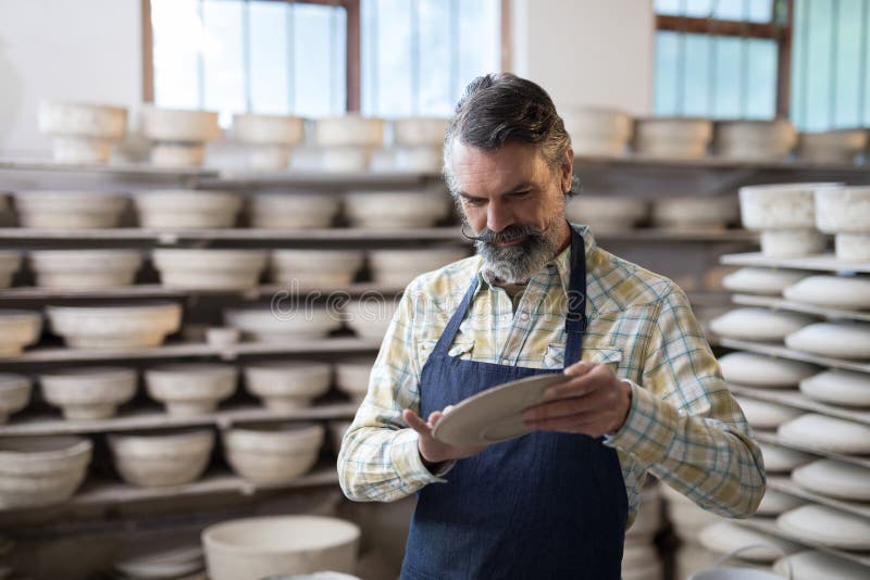 Male potter checking plate stock photo. Image of manual - 101221612