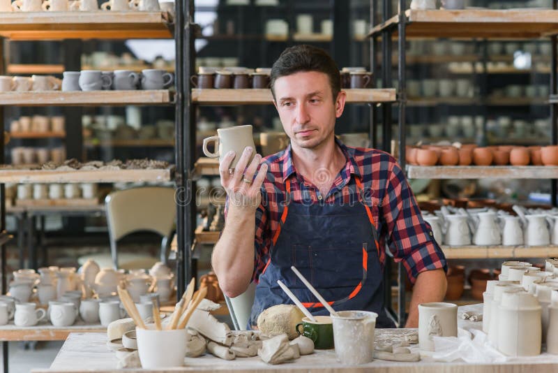 Male Potter Looking To the Handmade Cap during Work Day in the Pottery ...