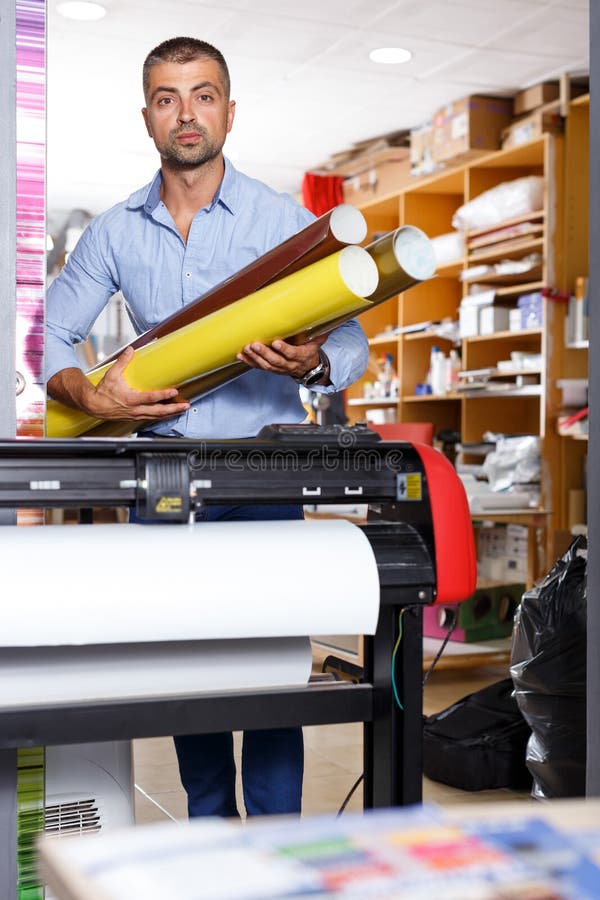 Male Printing Worker with Rolls of Colored Paper Stock Photo - Image of ...