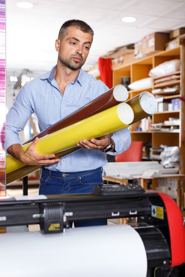 Male Printing Worker with Rolls of Colored Paper Stock Photo - Image of ...