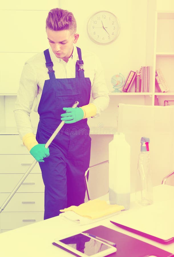 Male Professional Janitor Dusting in Office Stock Image - Image of ...