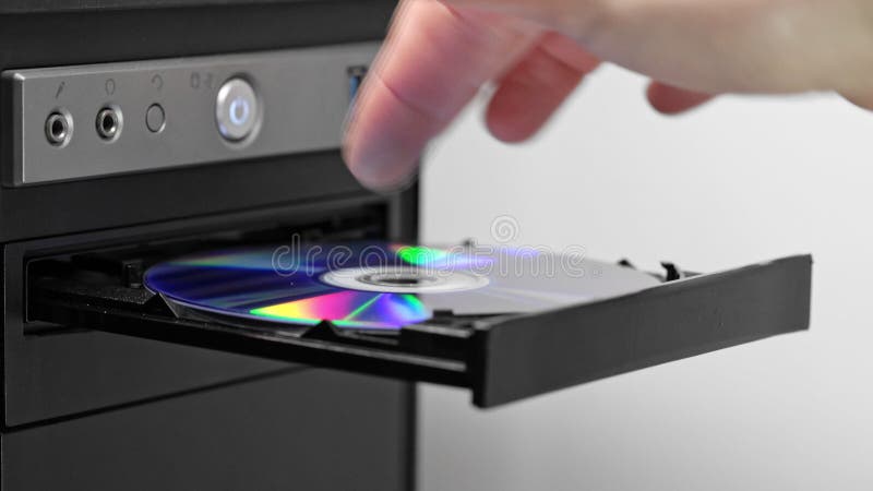 A Male Programmer Inserts a CD-DVD from a Computer Drive. View from ...