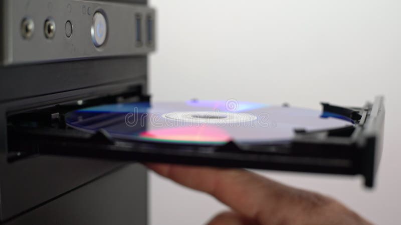 A Male Programmer Inserts a CD-DVD from a Computer Drive. View from ...