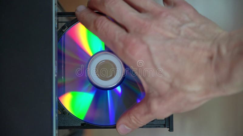 A Male Programmer Inserts a CD-DVD from a Computer Drive. View from ...