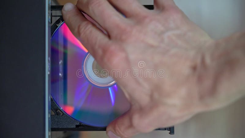 A Male Programmer Inserts a CD-DVD from a Computer Drive. View from ...