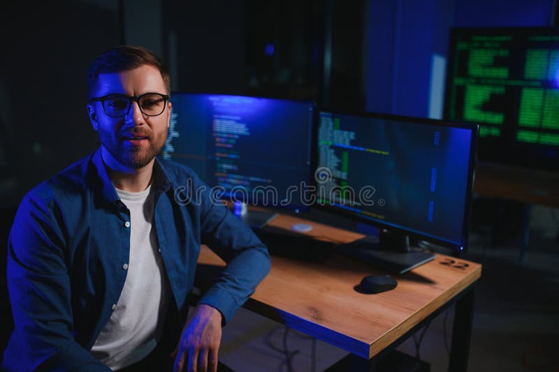 Male Programmer Working On Desktop Computer At White Desk In Office