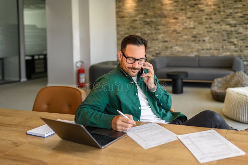 Male Project Manager in Glasses Talking Over Mobile Phone and Writing ...