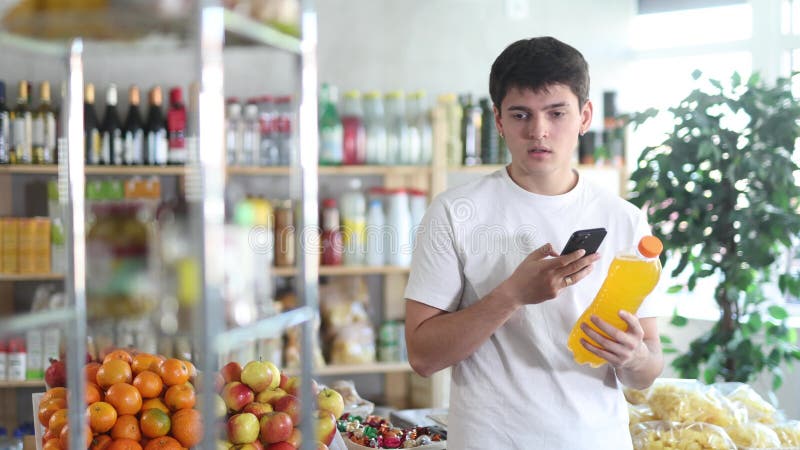 Male Purchaser Scanning QR Code or Barcode Bottle of Water in ...