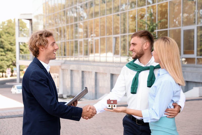 Male Real Estate Agent Shaking Hands With Clients Stock Image - Image ...