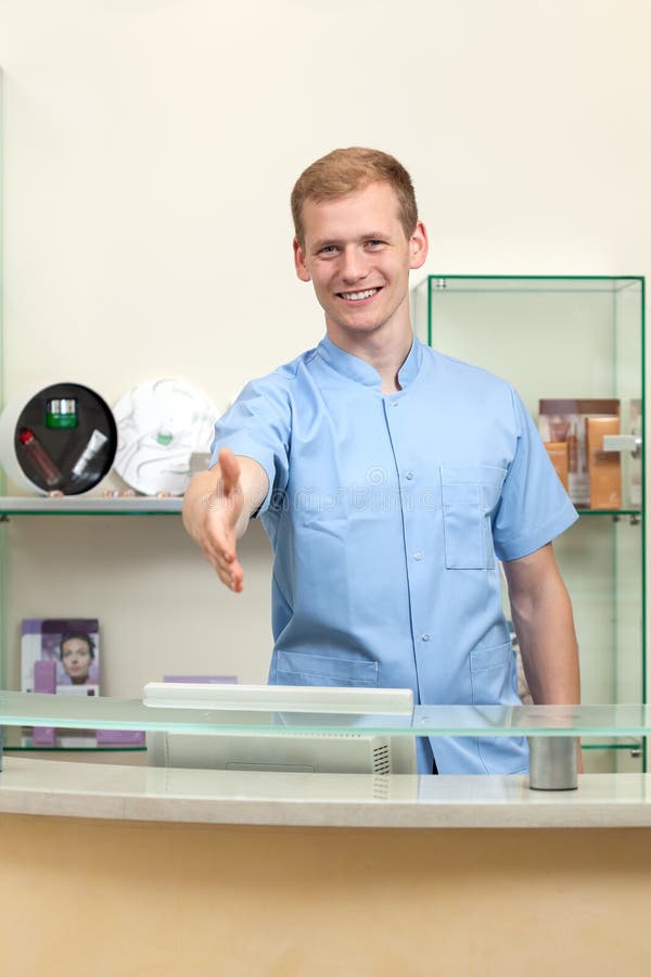 Male Receptionist Inviting New Customer Stock Photo - Image of ...
