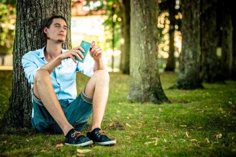 Male Relaxing Under Tree Outdoors Stock Image - Image of posing, park ...