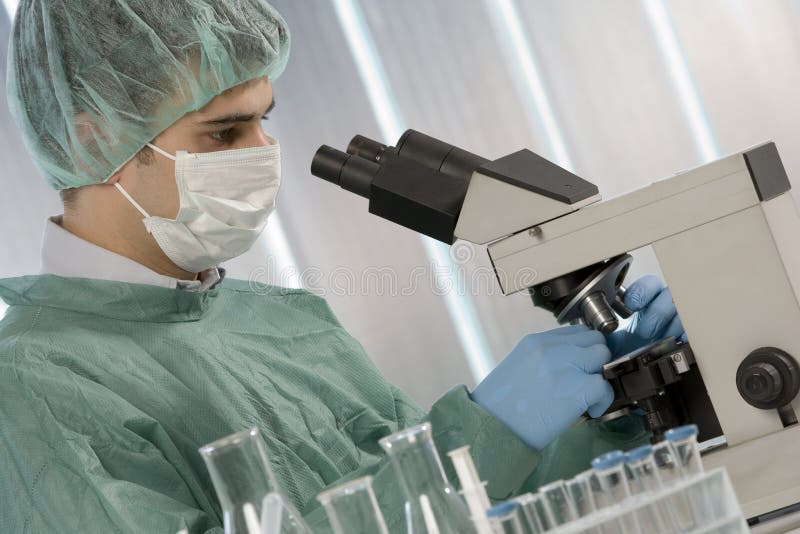 Male Researcher Looking through a Microscope in a Stock Image - Image ...