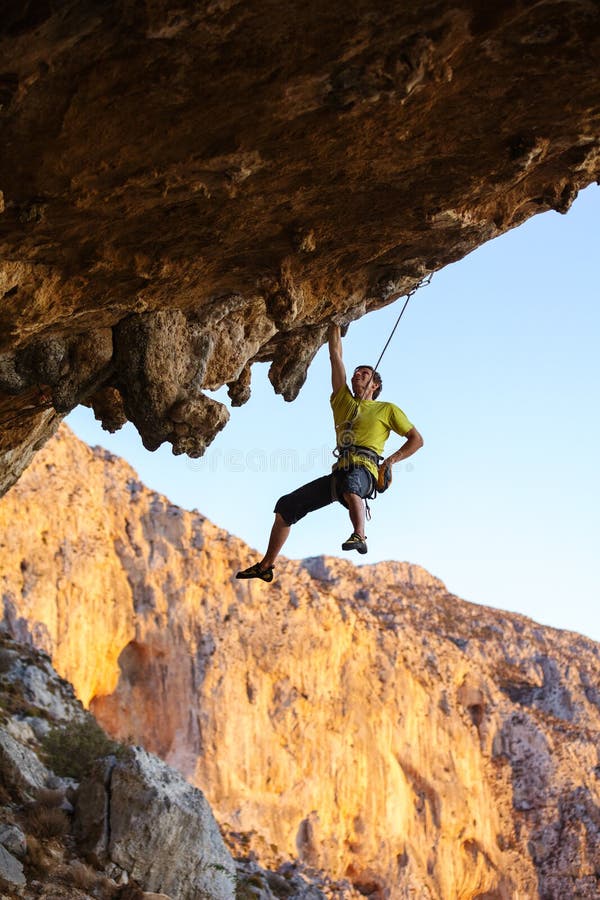 Male Rock Climber Hanging with One Hand on a Cliff Stock Photo - Image ...